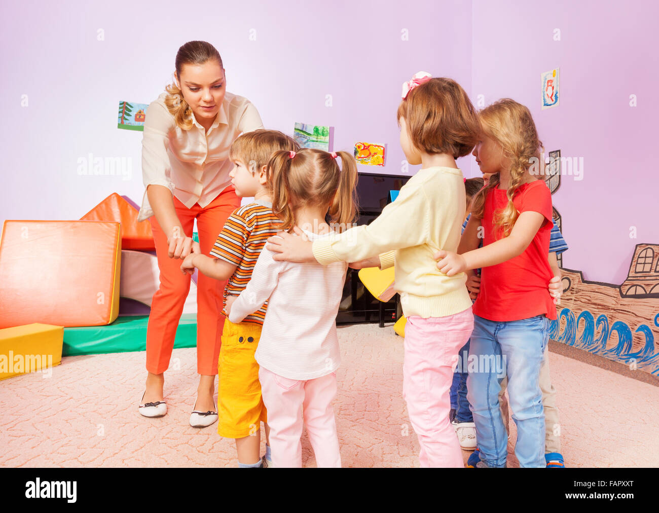 Group of kids go after each other with teacher Stock Photo - Alamy