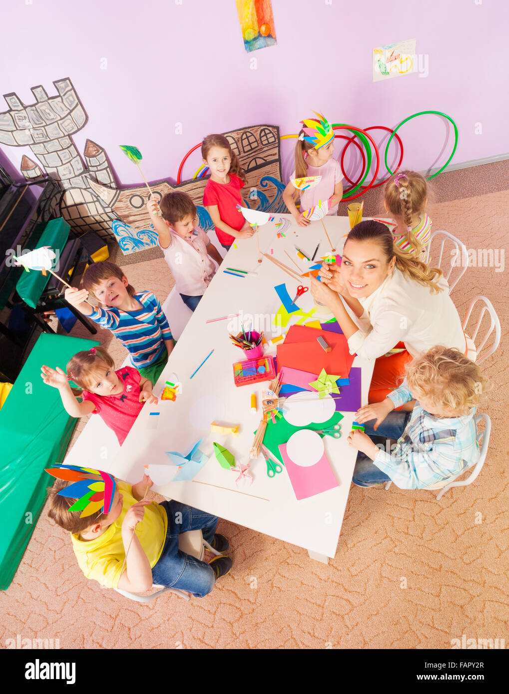 Kids around table in kindergarten class from above Stock Photo - Alamy