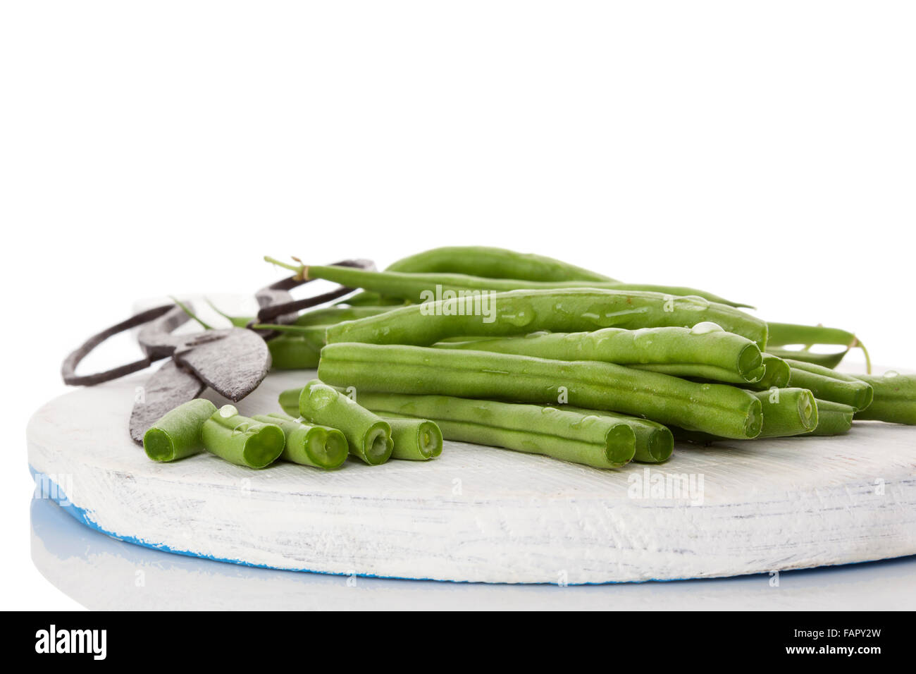 Fresh green beans with water drops on wooden chopping board isolated on ...