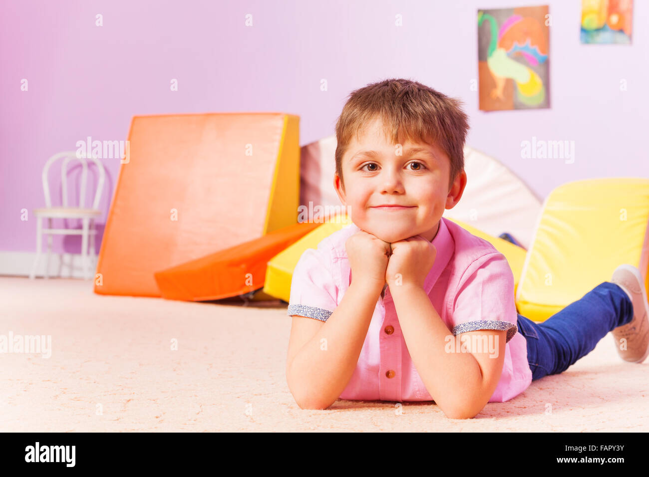 Portrait of boy lay on the floor and smile Stock Photo - Alamy