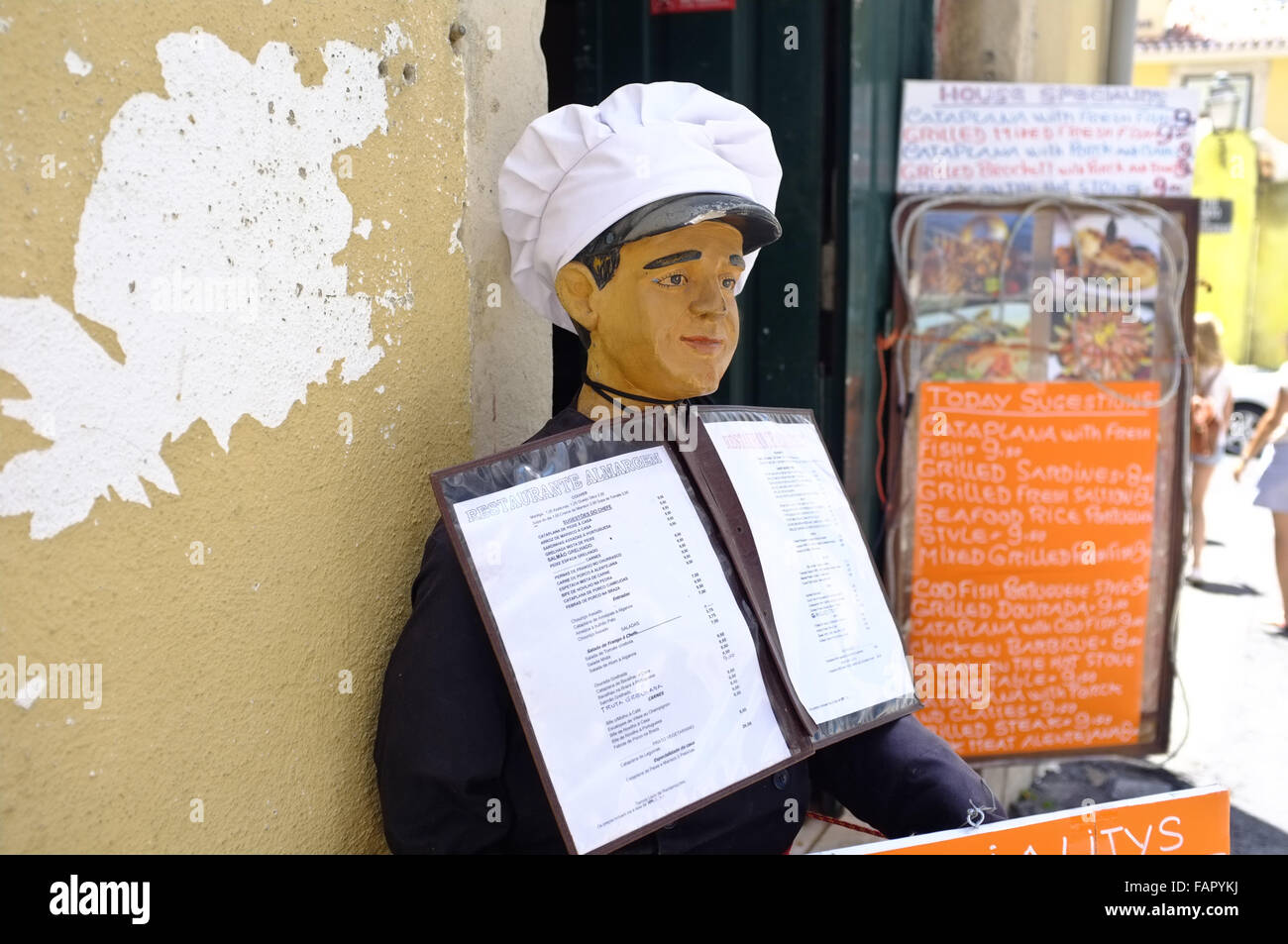Model of chef outside restaurant holding menu in Lisbon Stock Photo - Alamy