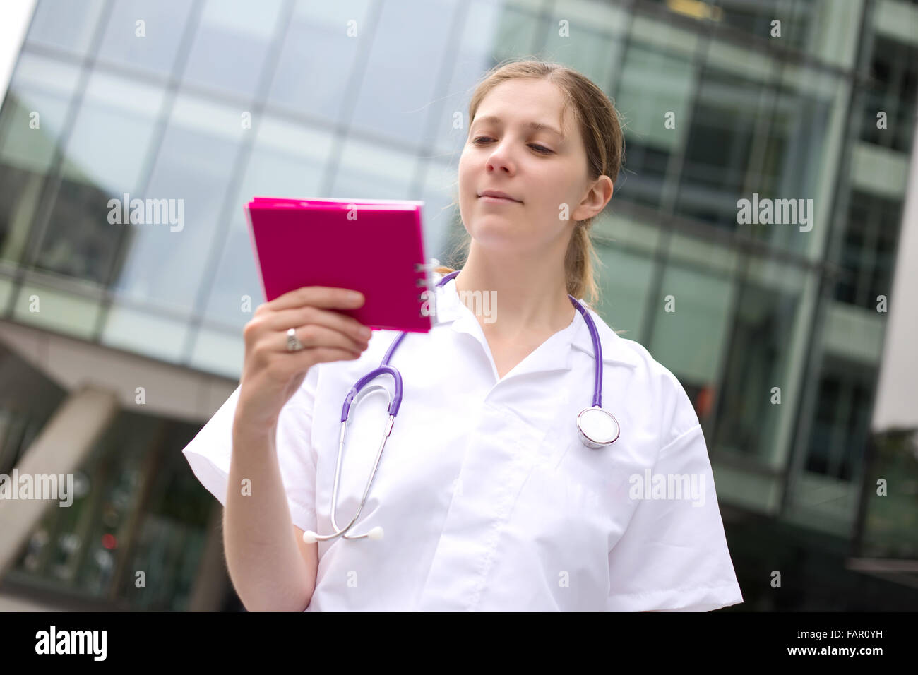 young doctor reading a notepad Stock Photo - Alamy