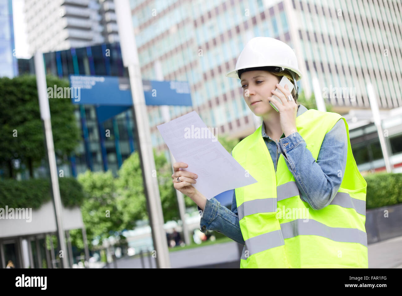 construction worker reading a document on the phone Stock Photo - Alamy
