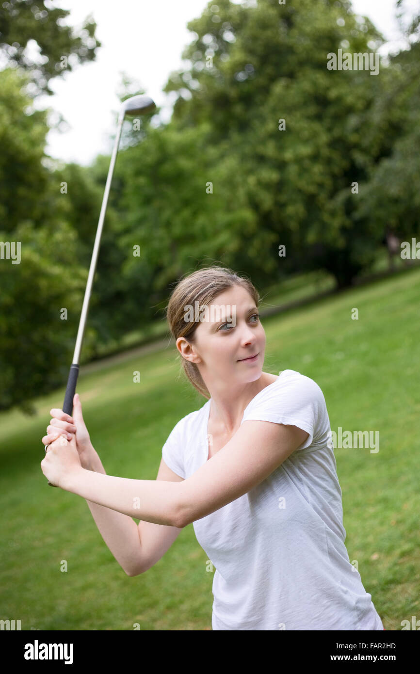 young woman teeing off on the golf course Stock Photo - Alamy