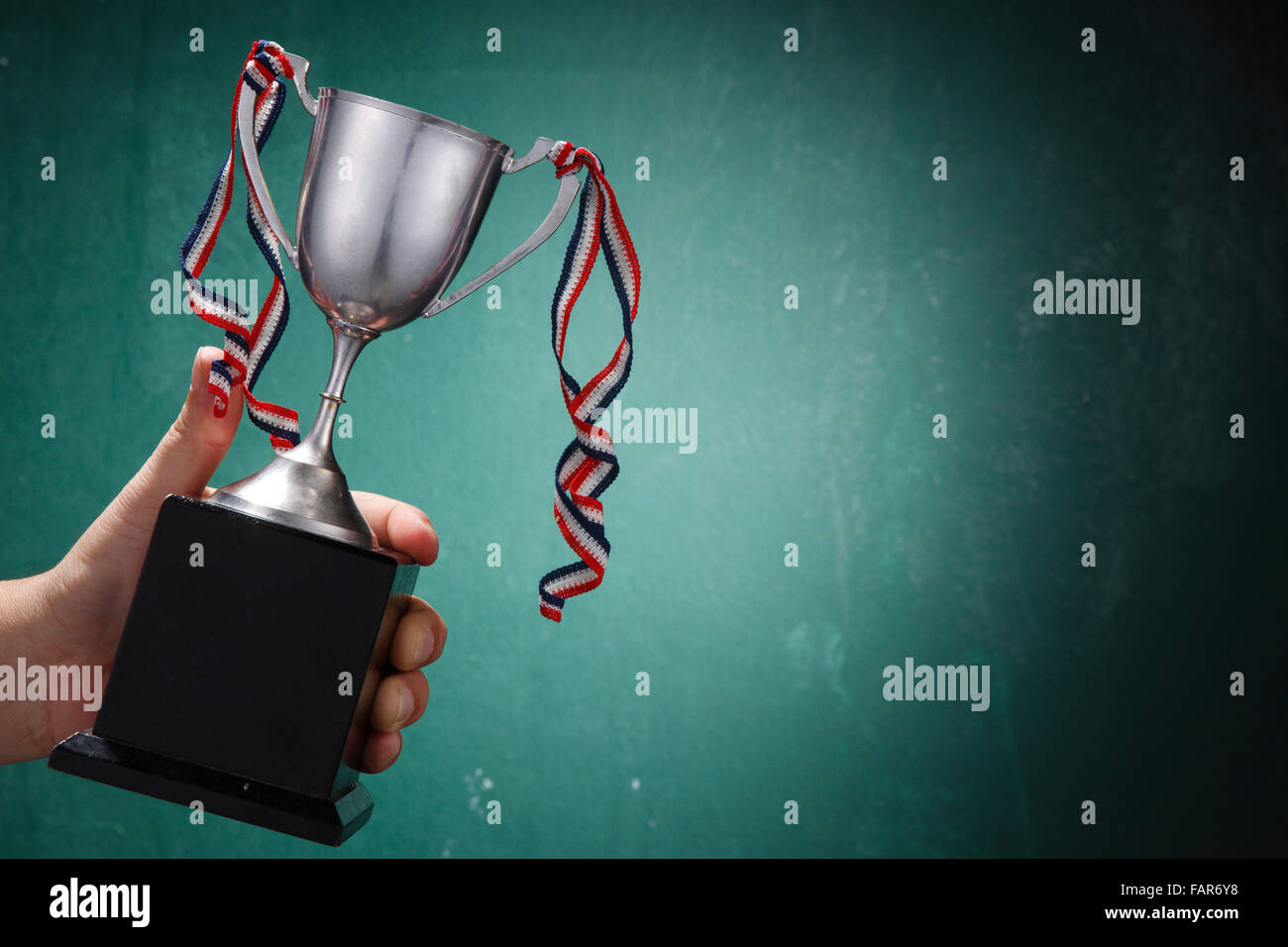 Human hand holding a silver trophy Stock Photo - Alamy