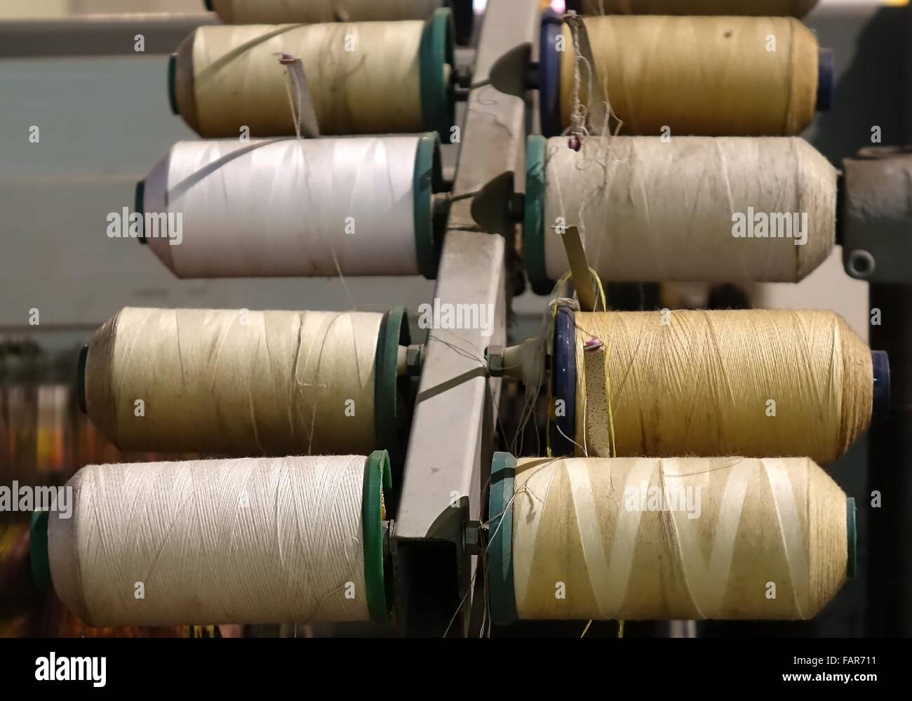 An old piece of textile manufacturing equipment with various spools of ...
