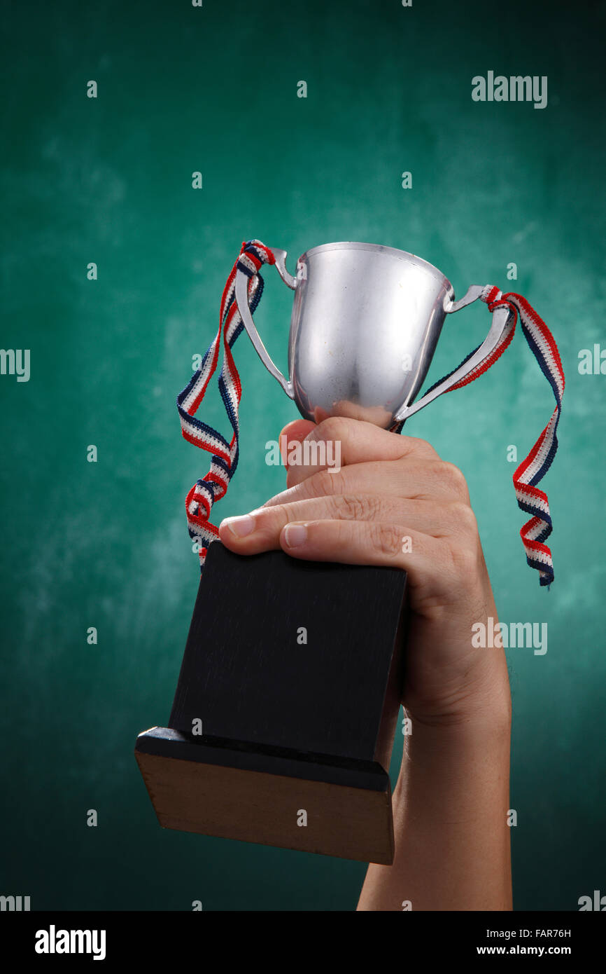 Human hand holding a silver trophy Stock Photo - Alamy