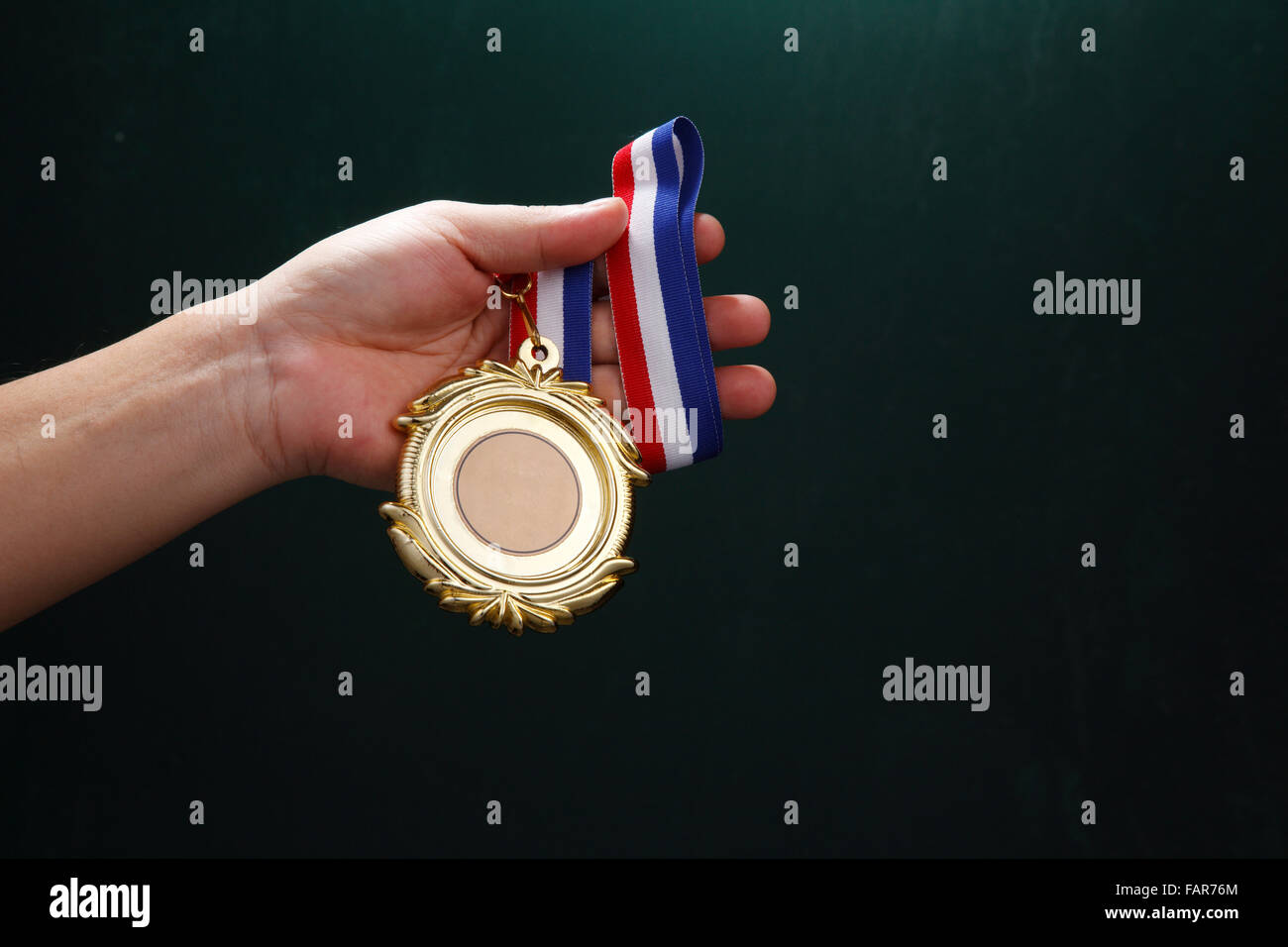 Human hand holding a medal Stock Photo - Alamy