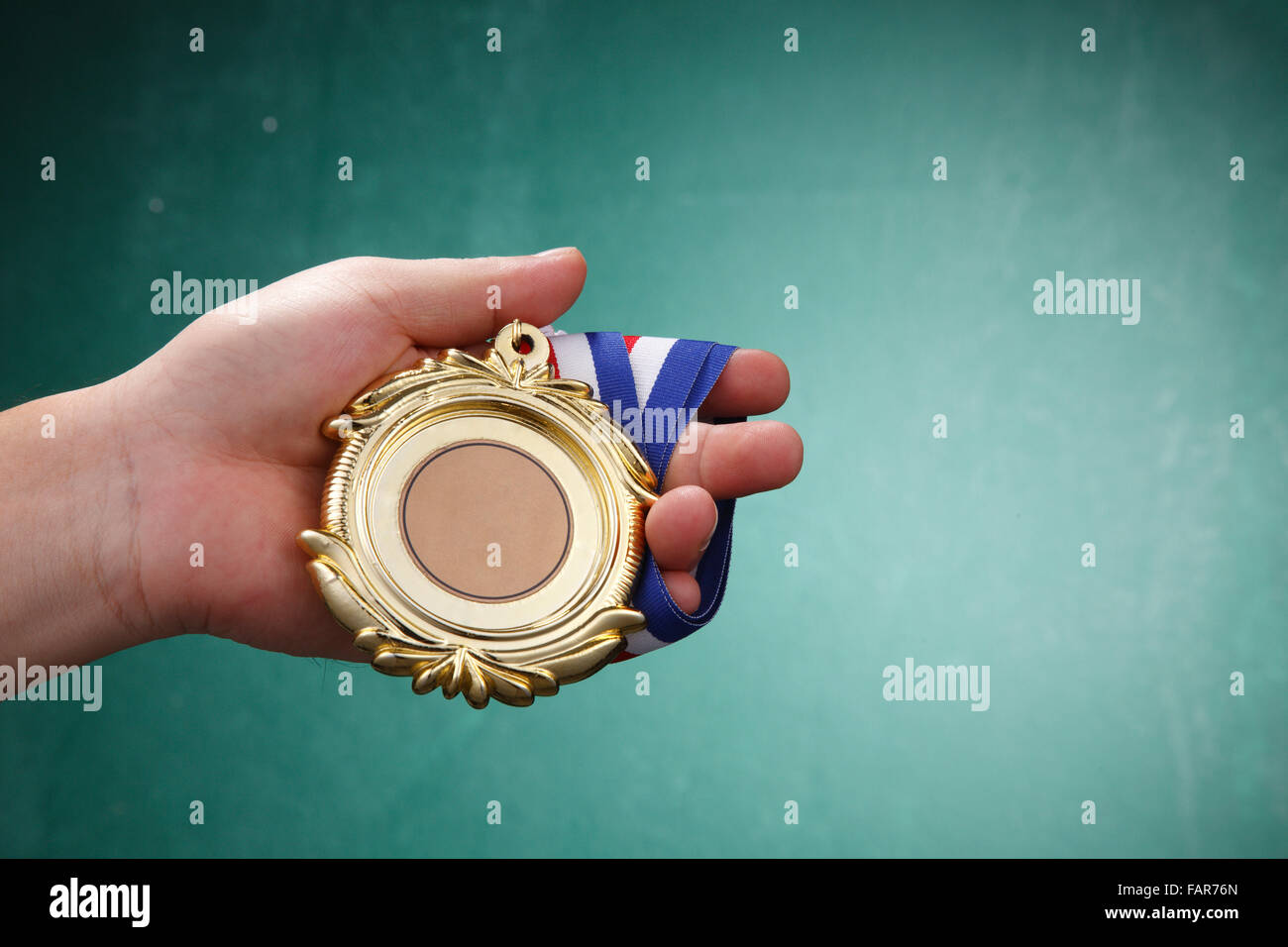 Human hand holding a medal Stock Photo - Alamy