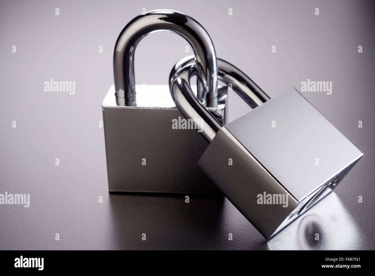 Two padlocks interlocked together on the background Stock Photo - Alamy