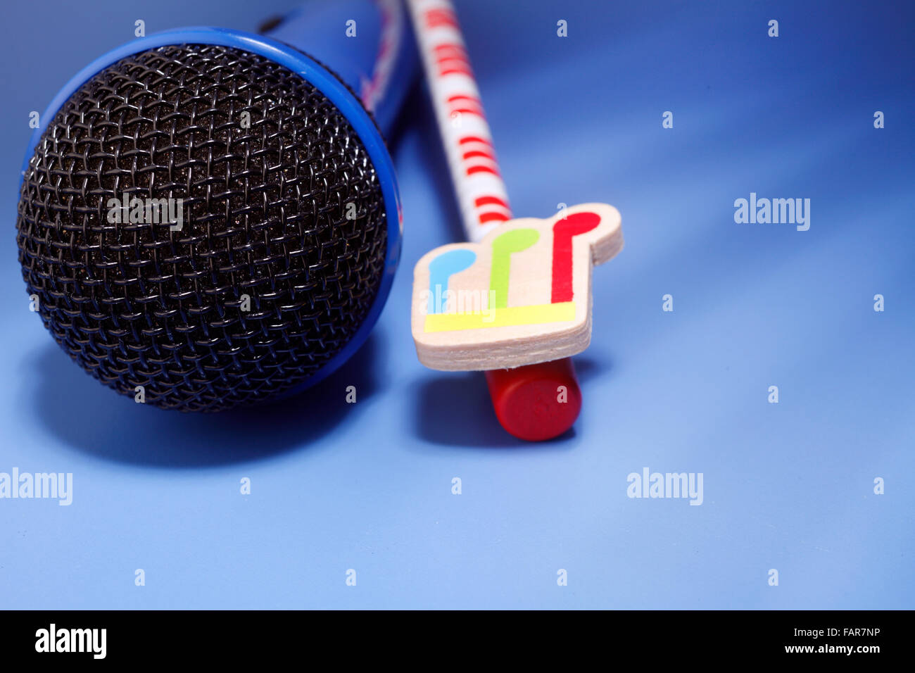 Microphone and pencil isolated on the blue background Stock Photo - Alamy