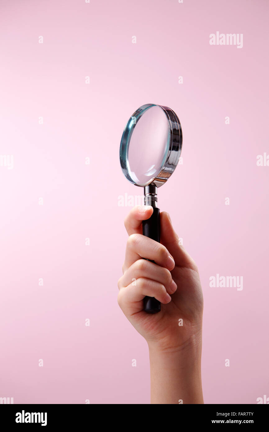 Human hand holding a magnifying glass Stock Photo - Alamy