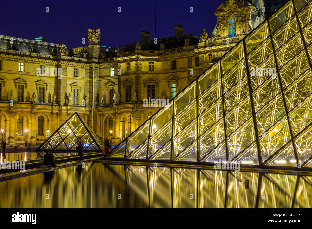 Louvre Museum main entrance and fountains at dusk, Paris Stock Photo ...