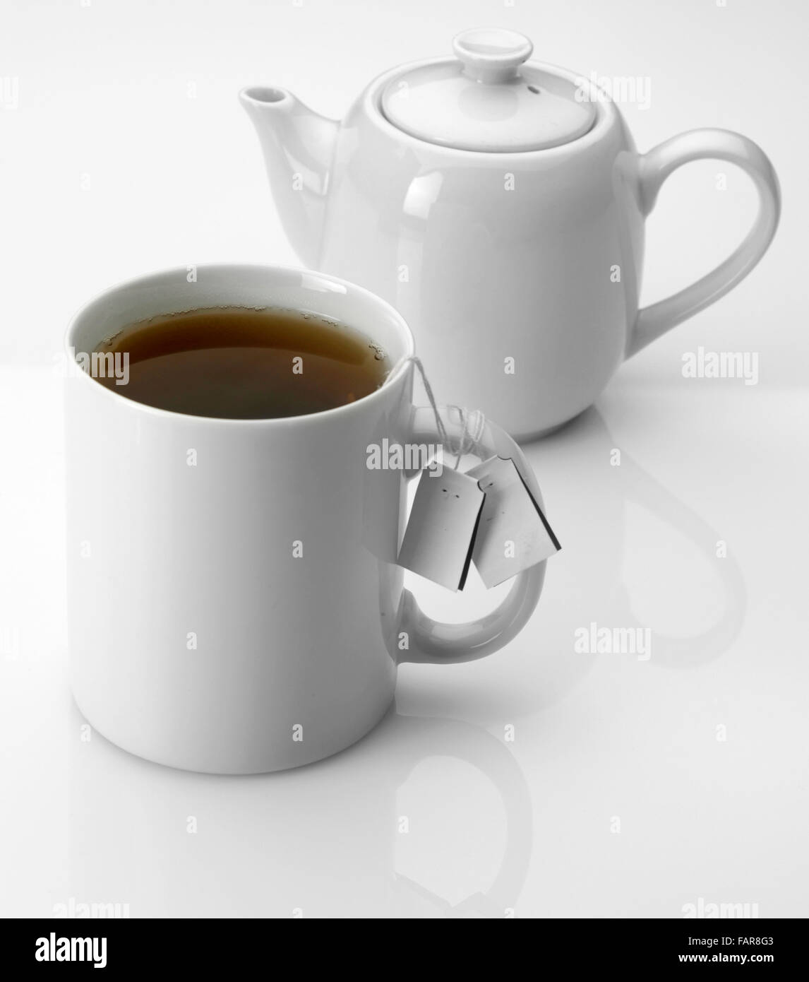mug with tea as foreground of tea pot Stock Photo - Alamy
