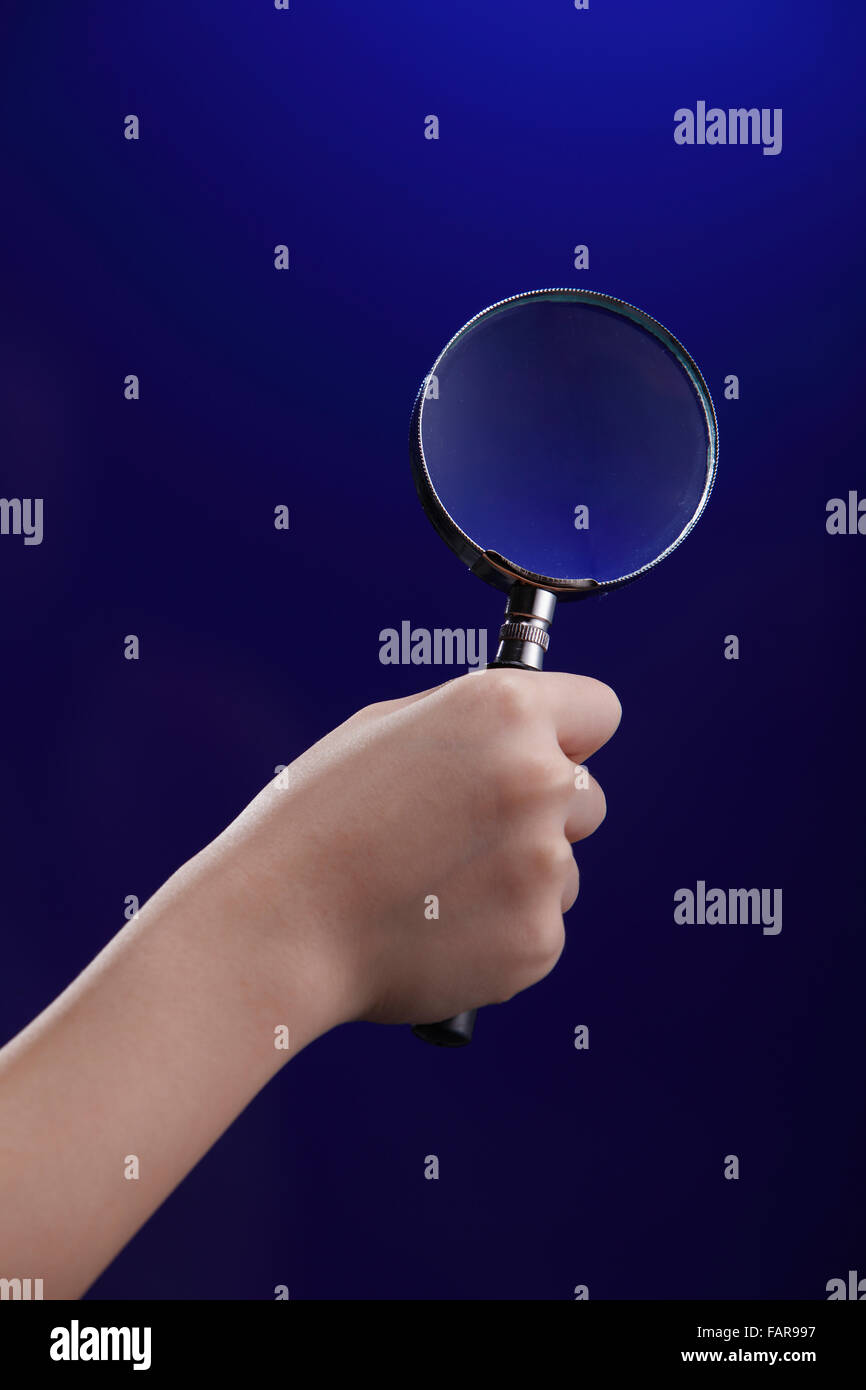 Human hand holding a magnifying glass Stock Photo - Alamy