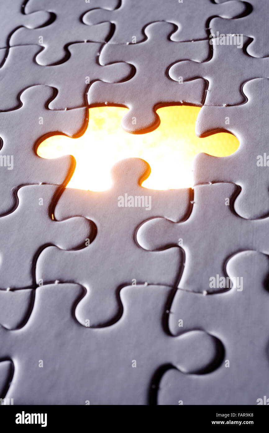 Light shining out of a missing puzzle piece Stock Photo - Alamy