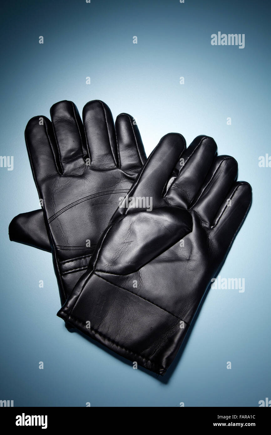 A pair of black gloves isolated on the blue background Stock Photo - Alamy