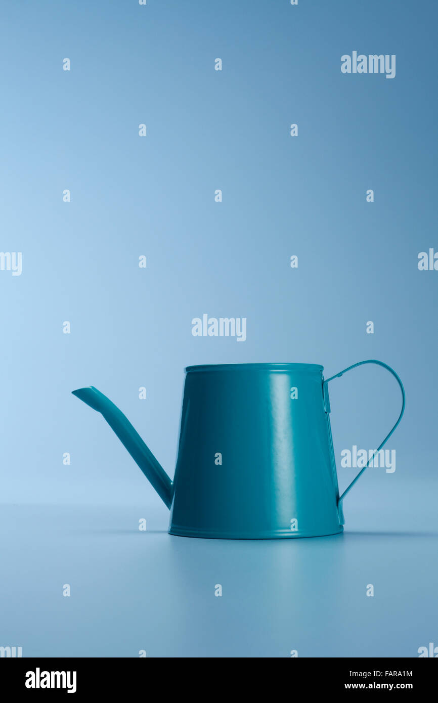 Watering can isolated on the blue background Stock Photo - Alamy