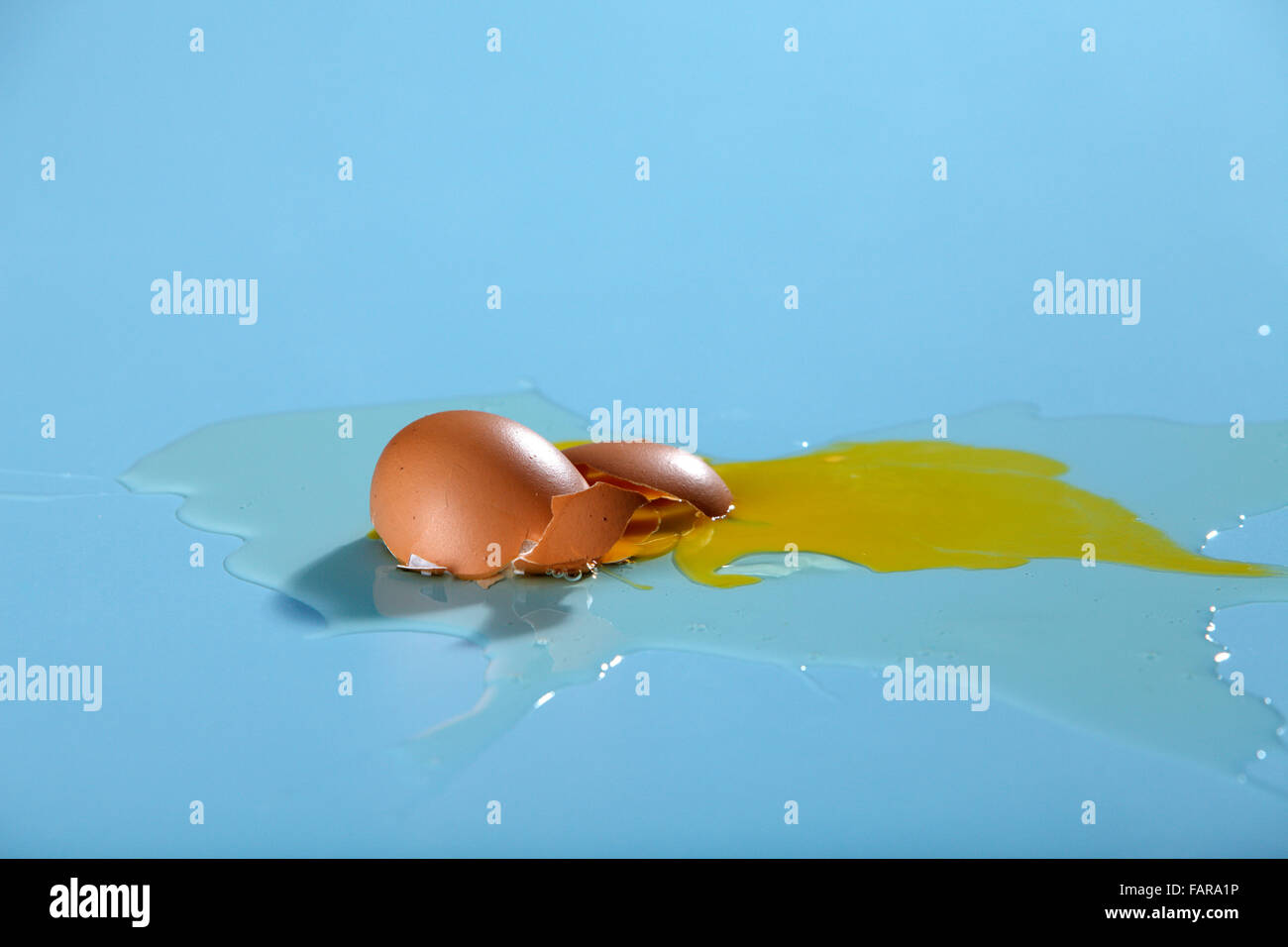 Splattered egg isolated on blue background Stock Photo - Alamy