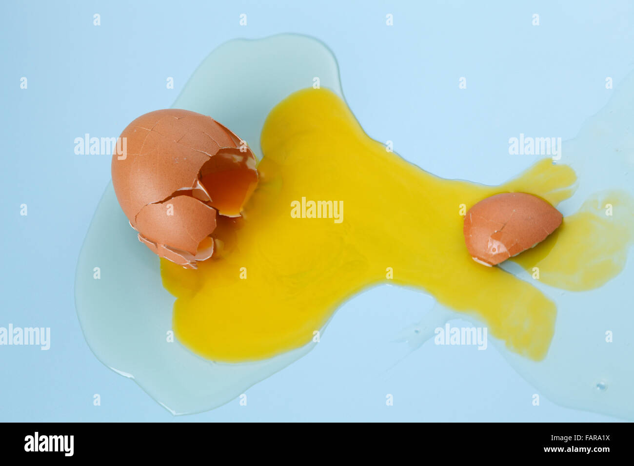 Splattered egg isolated on blue background Stock Photo - Alamy