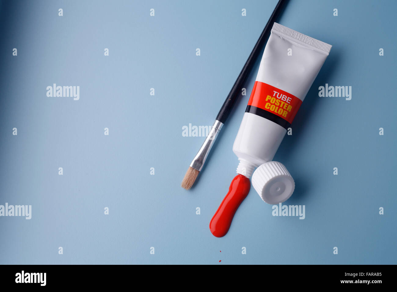 Paintbrush with a tube of paint isolated on blue background Stock Photo ...