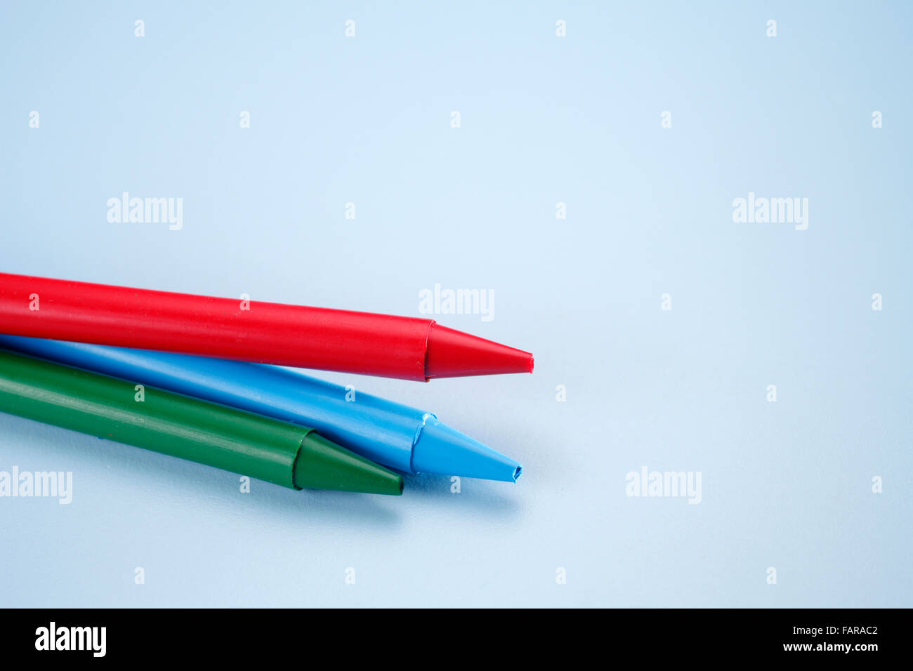 Three crayons isolated on the blue background Stock Photo - Alamy
