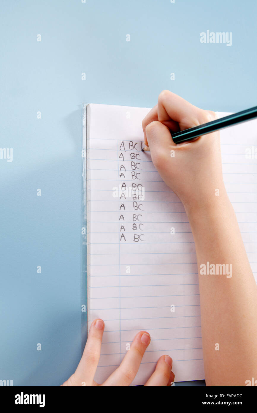 Human hand writing answers on excercise book Stock Photo - Alamy