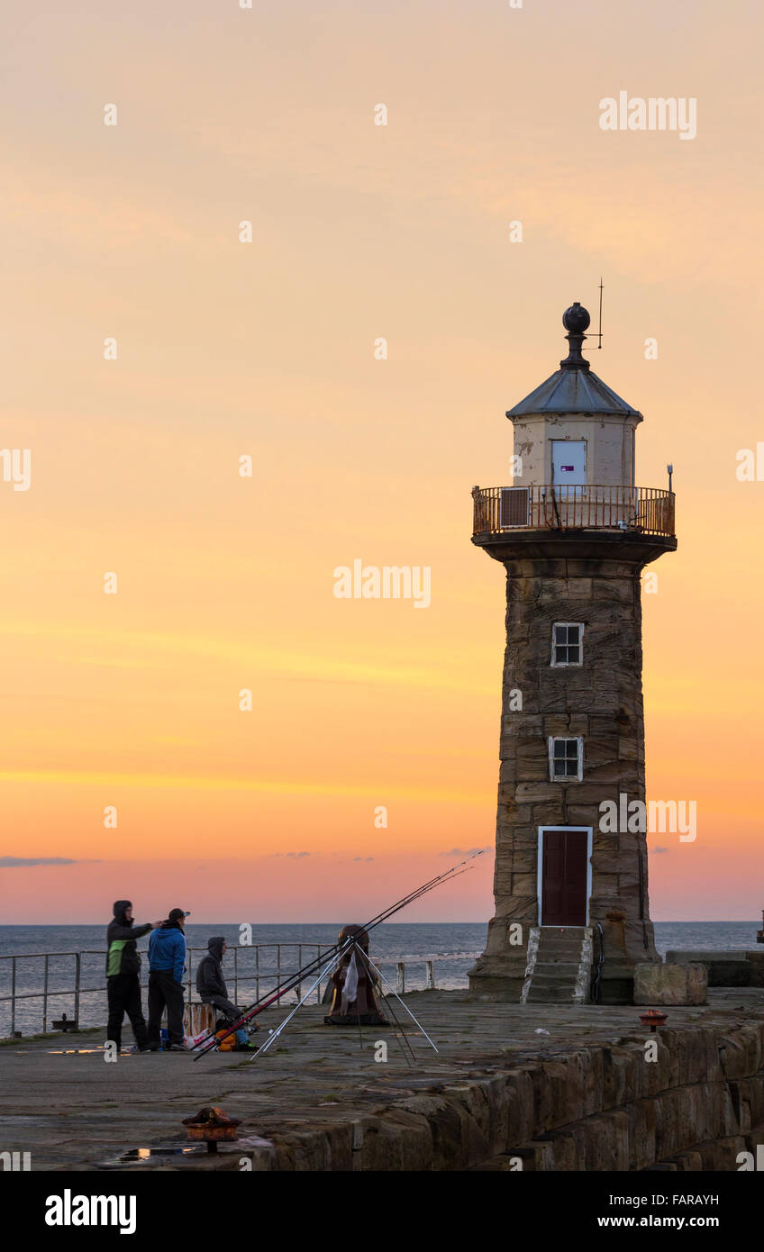 Fishermen on Whitby pier at sunset. Whitby, North Yorkshire, England ...