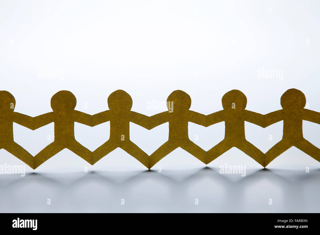 Paper chain holding hands together Stock Photo - Alamy