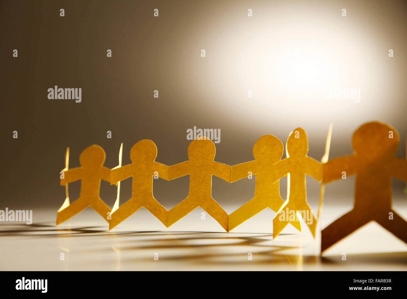 Paper men holding hands together Stock Photo - Alamy