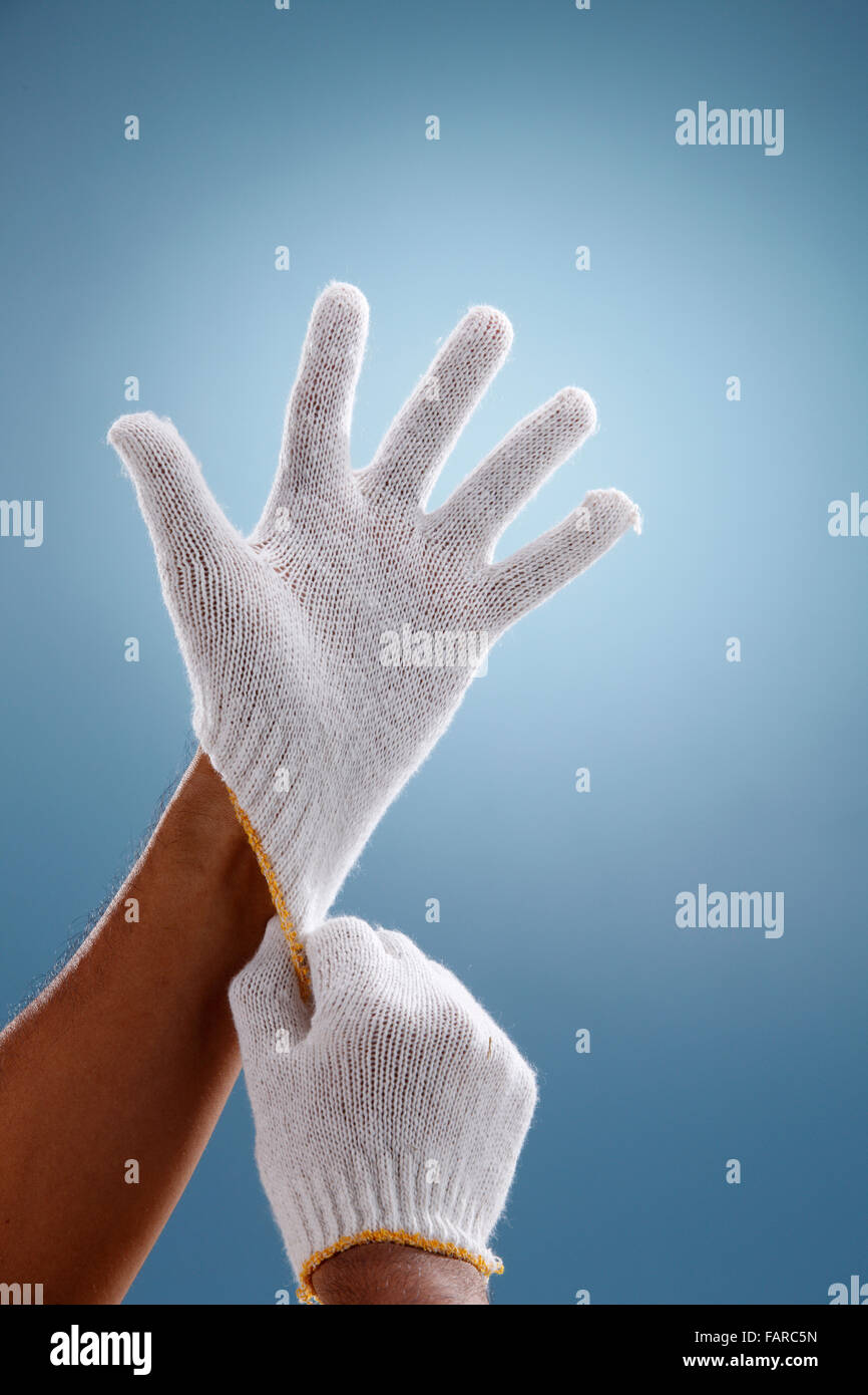Hands putting on gloves over a creative blue background Stock Photo - Alamy