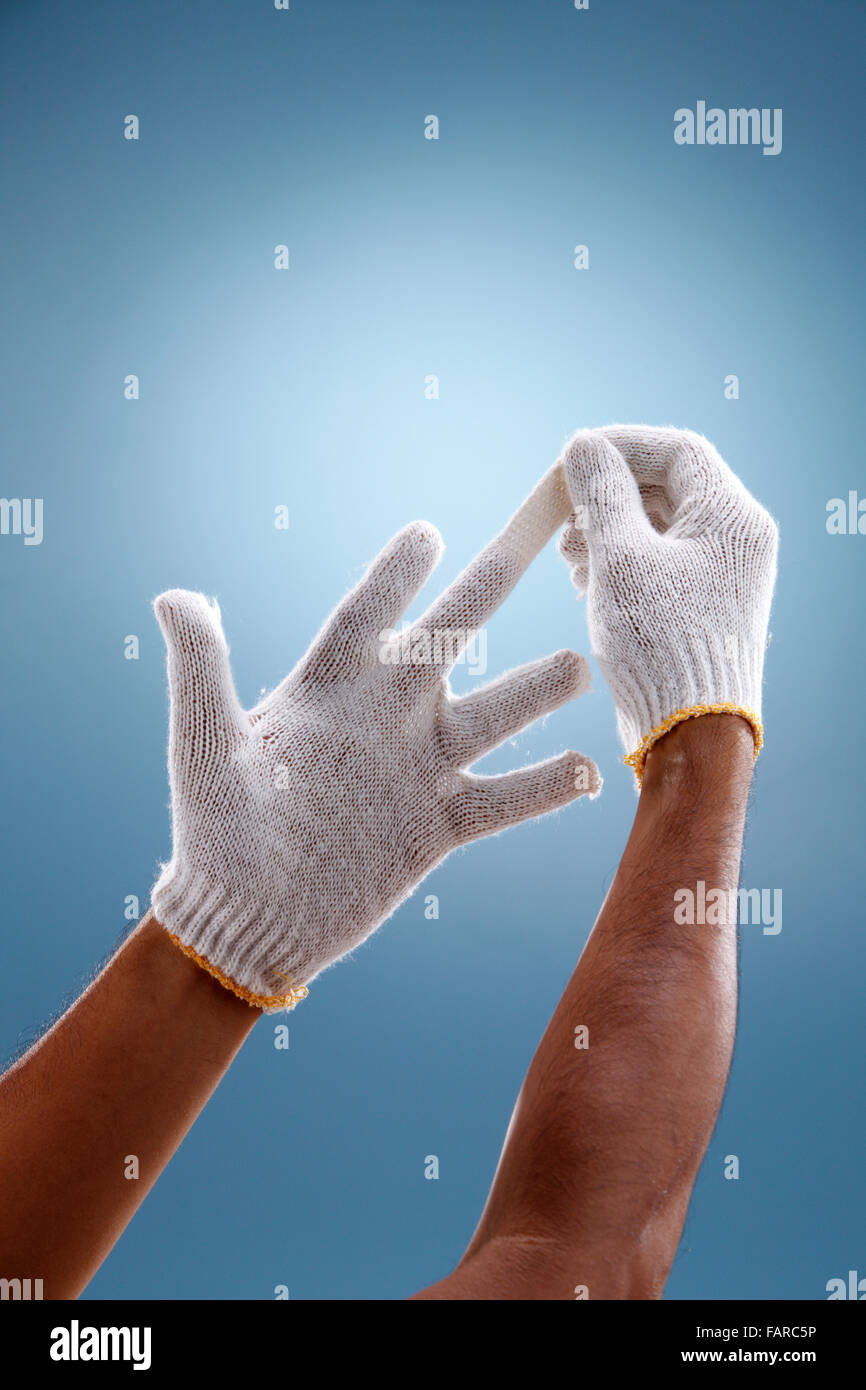 Hands putting on gloves over a creative blue background Stock Photo - Alamy