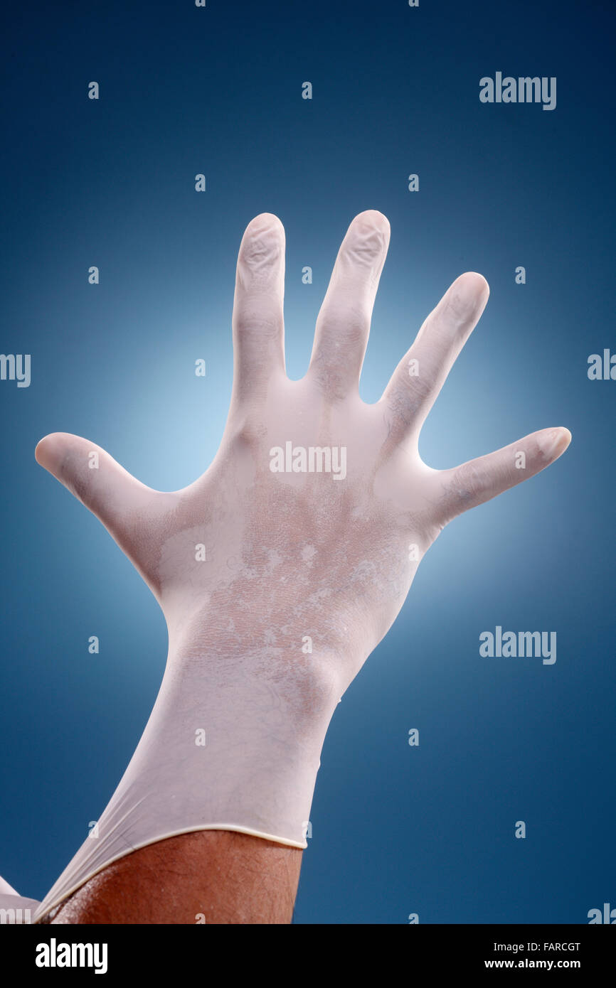 Hands putting on surgical gloves over a creative blue background Stock ...