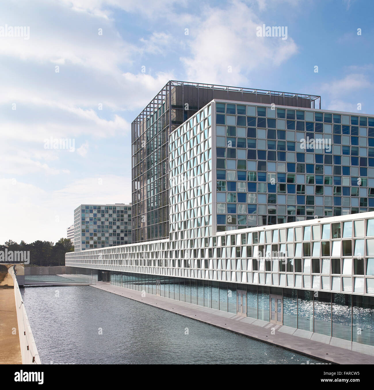 Perspective along exterior grid facade of office towers and moat-style ...