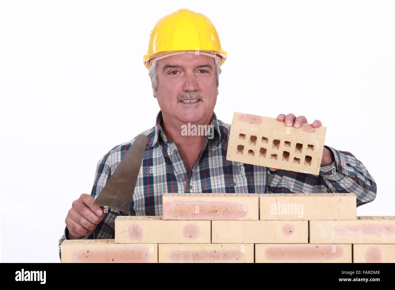 Bricklayer building wall Stock Photo - Alamy
