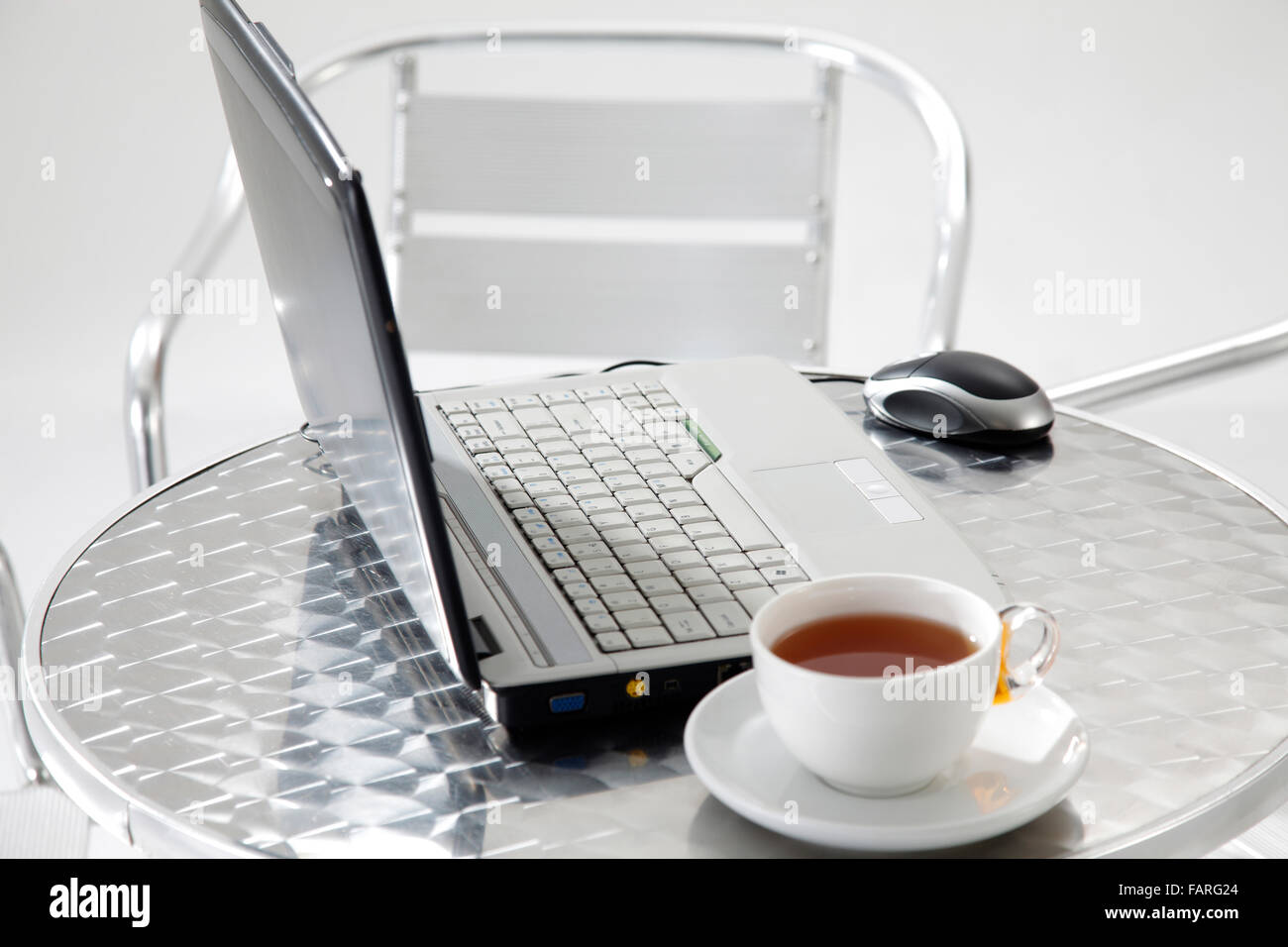 A laptop and a cup of tea on a table Stock Photo - Alamy