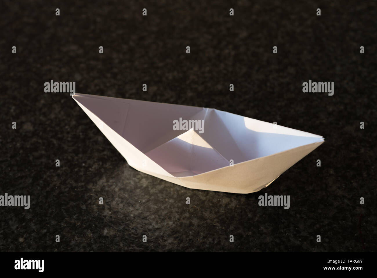 folded white paper ship on a black background Stock Photo - Alamy