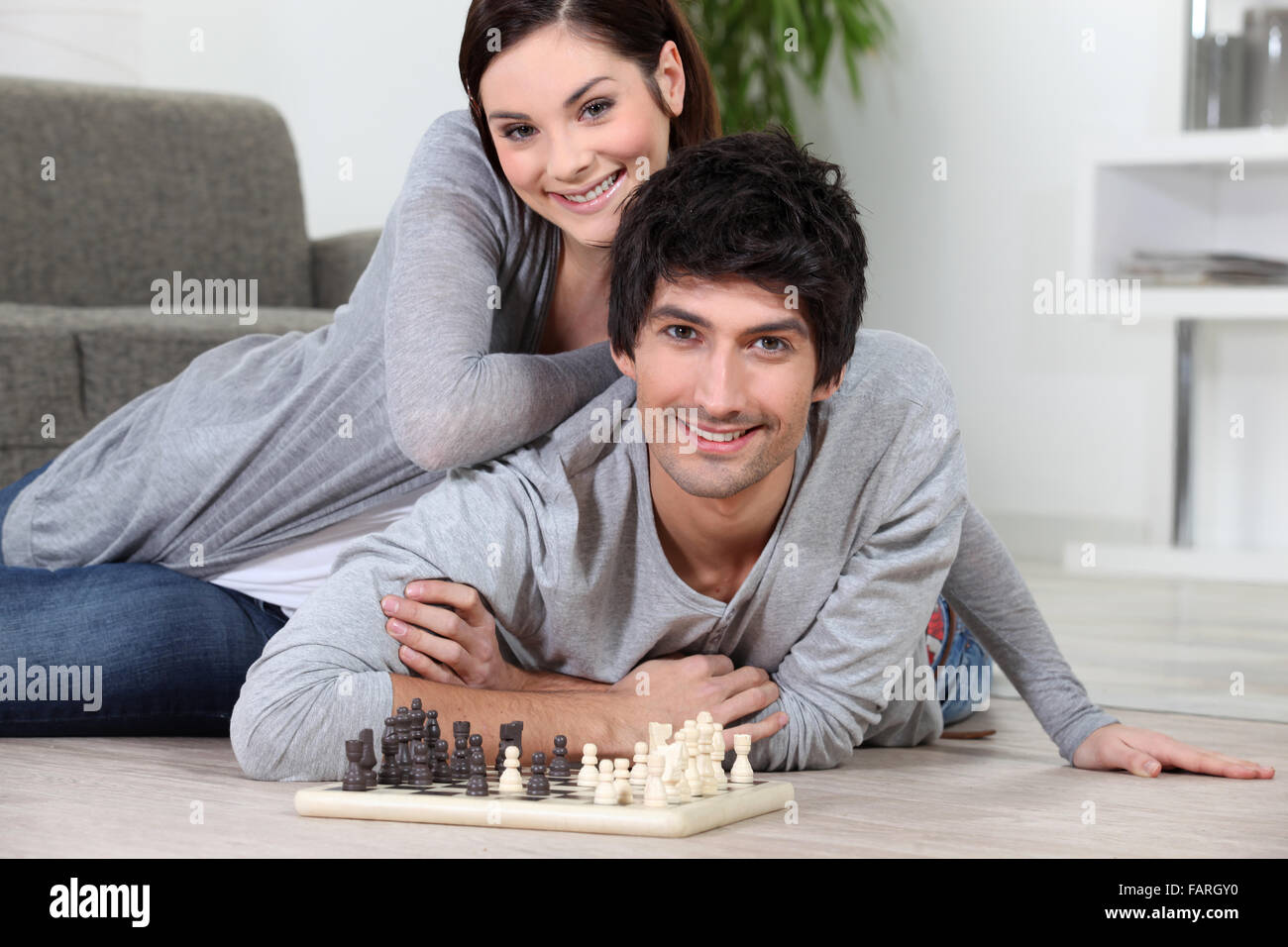 Couple laying on the floor playing chess Stock Photo - Alamy