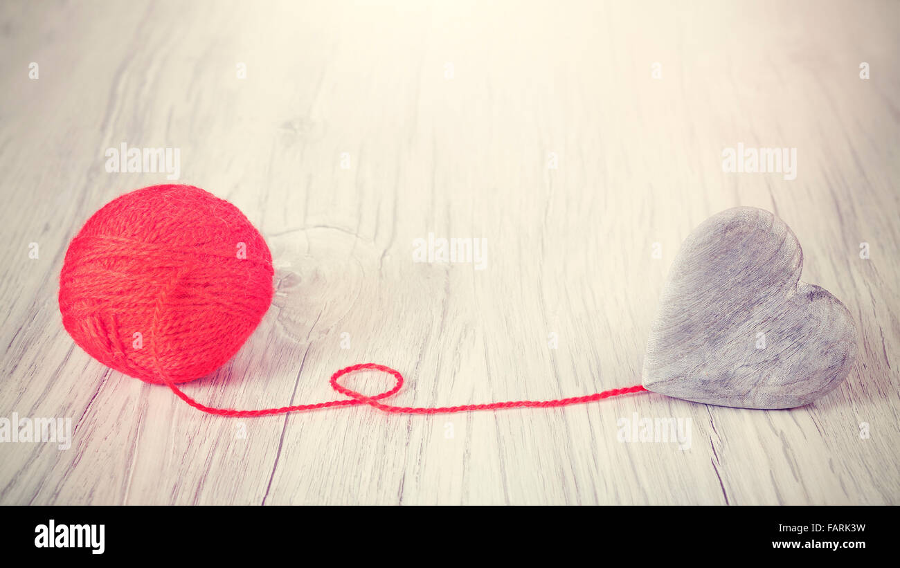 Wooden heart connected to red yarn, concept picture Stock Photo - Alamy