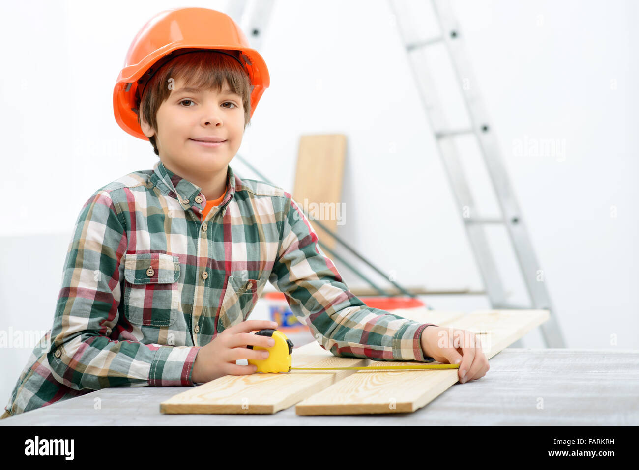Positive boy holding tape measure Stock Photo - Alamy