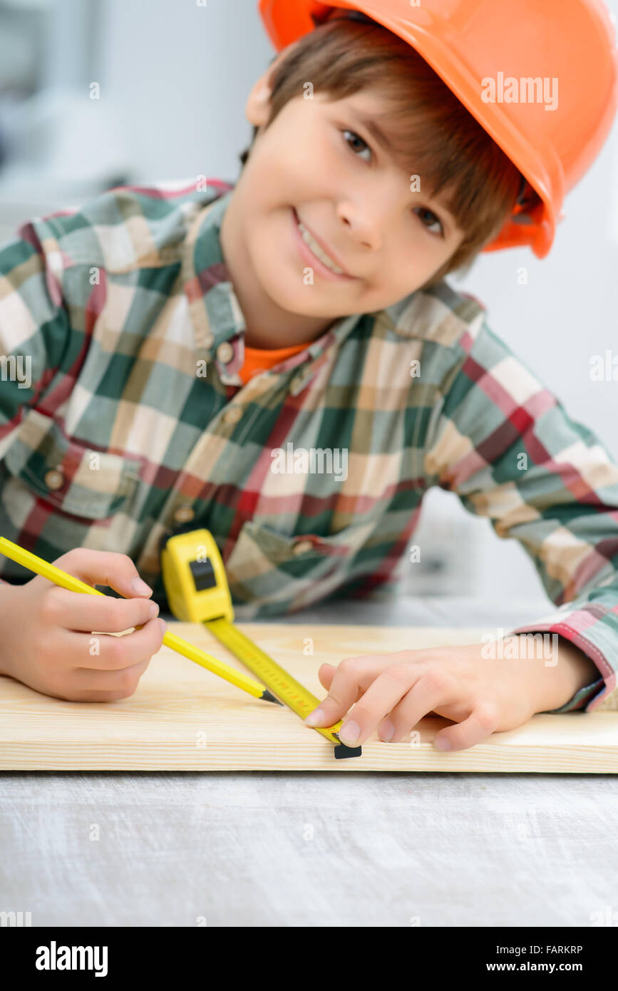 Positive boy holding tape measure Stock Photo - Alamy