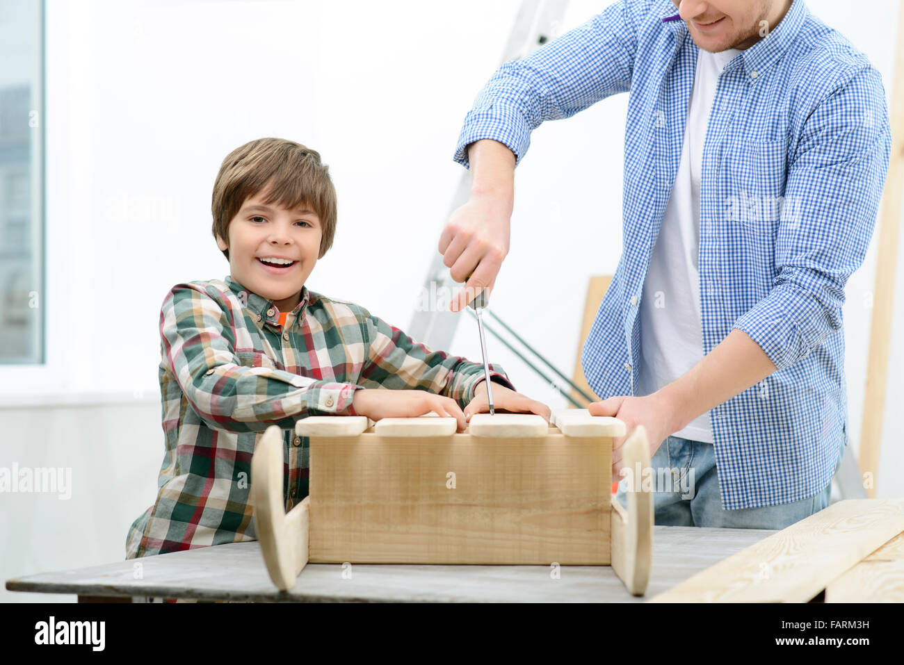 Positive father and son doing renovation Stock Photo - Alamy