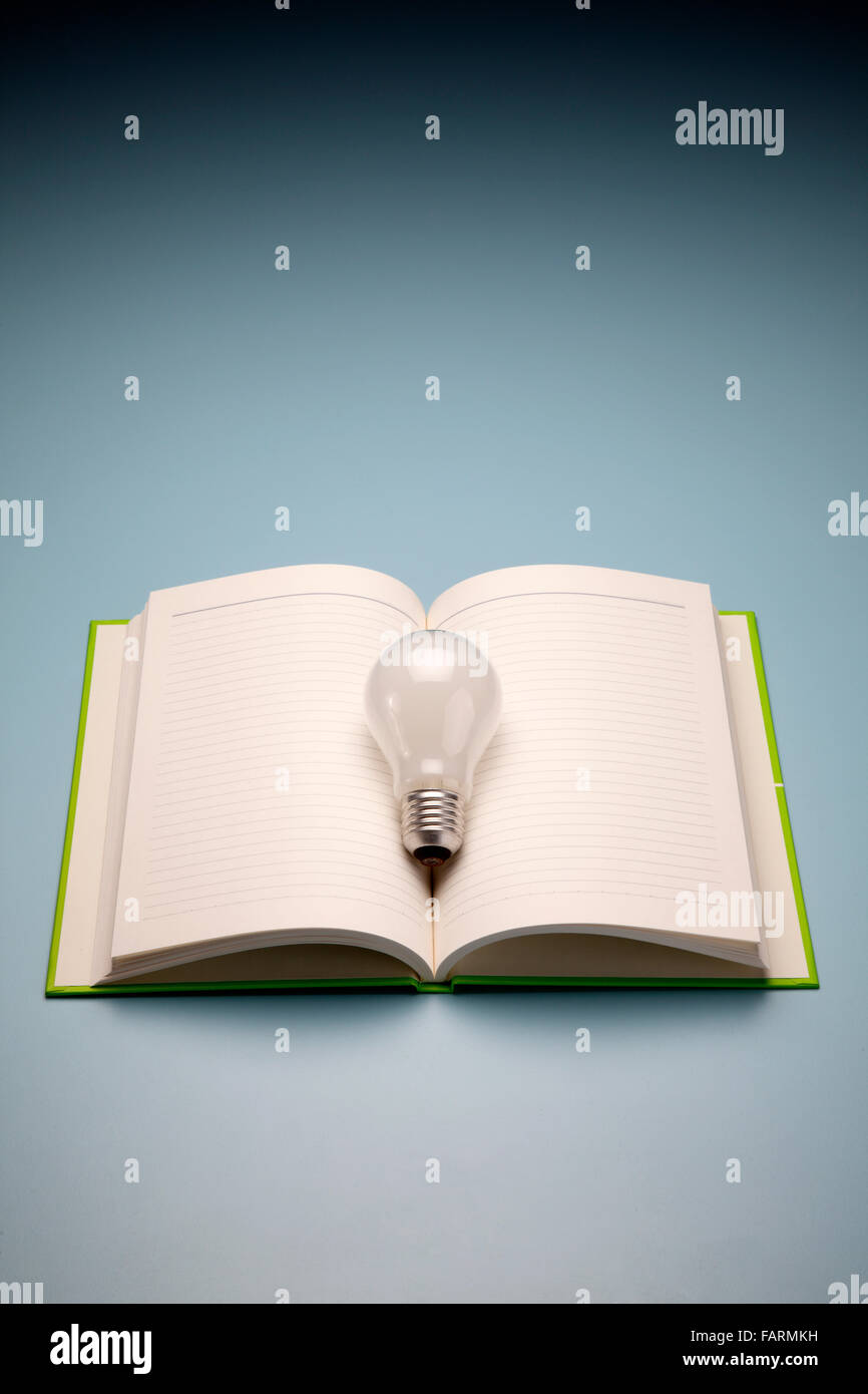 A book and lamp, isolated on dark background for concept idea Stock ...