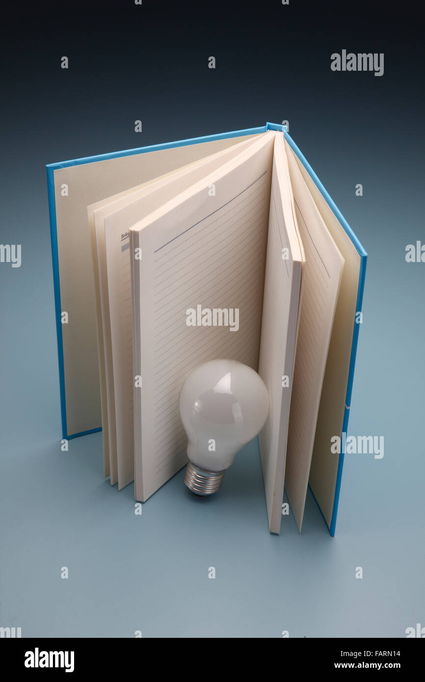 A book and lamp, isolated on dark background for concept idea Stock ...