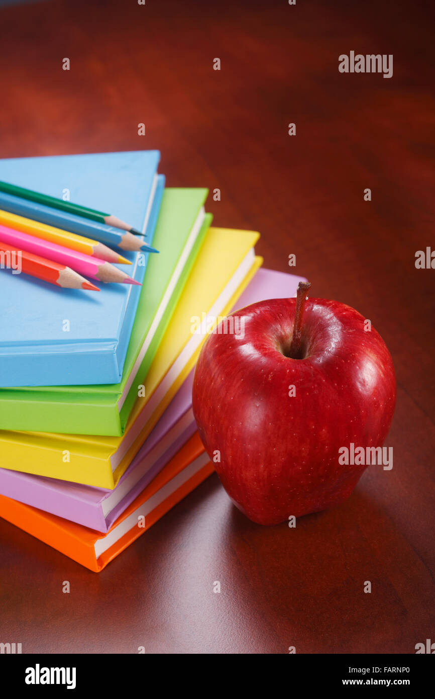 A stack of books with some pencils and an apple Stock Photo - Alamy