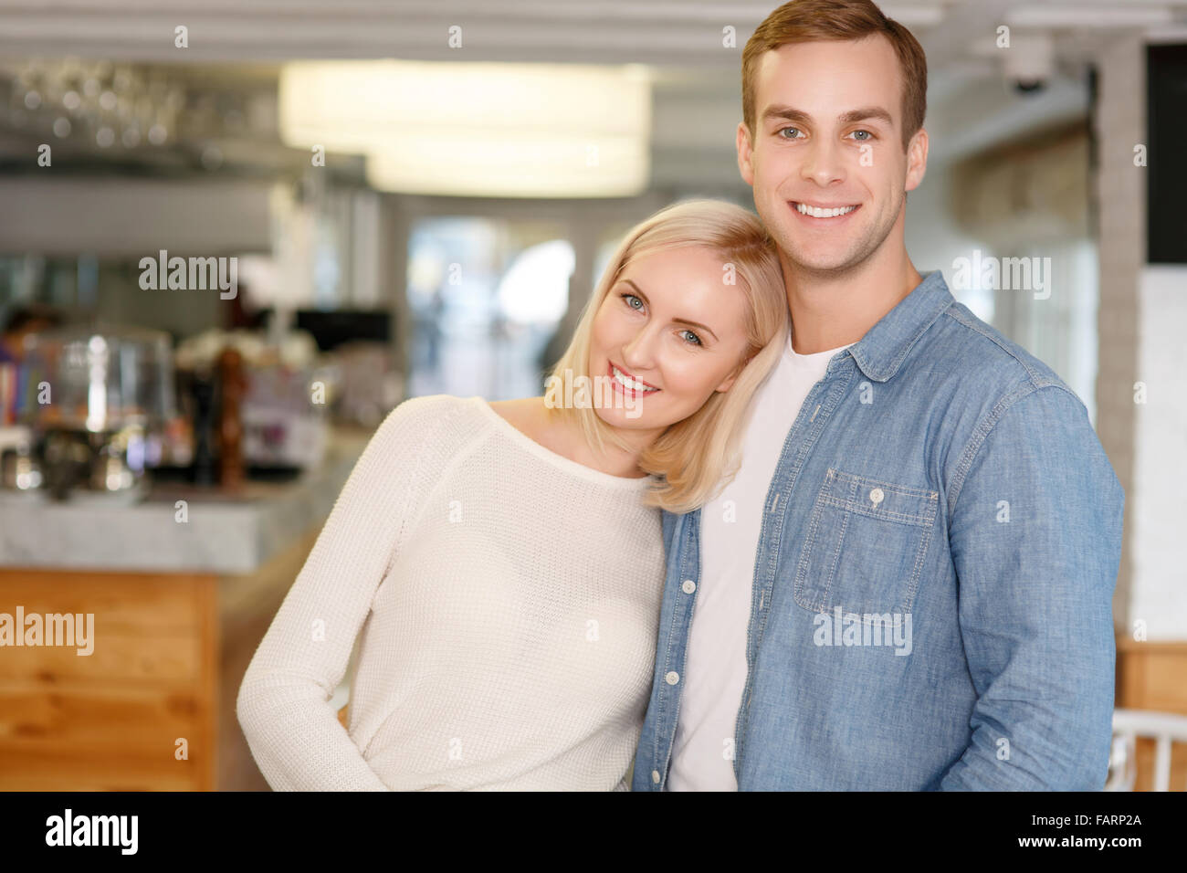 Nice young couple standing in the cafe Stock Photo - Alamy