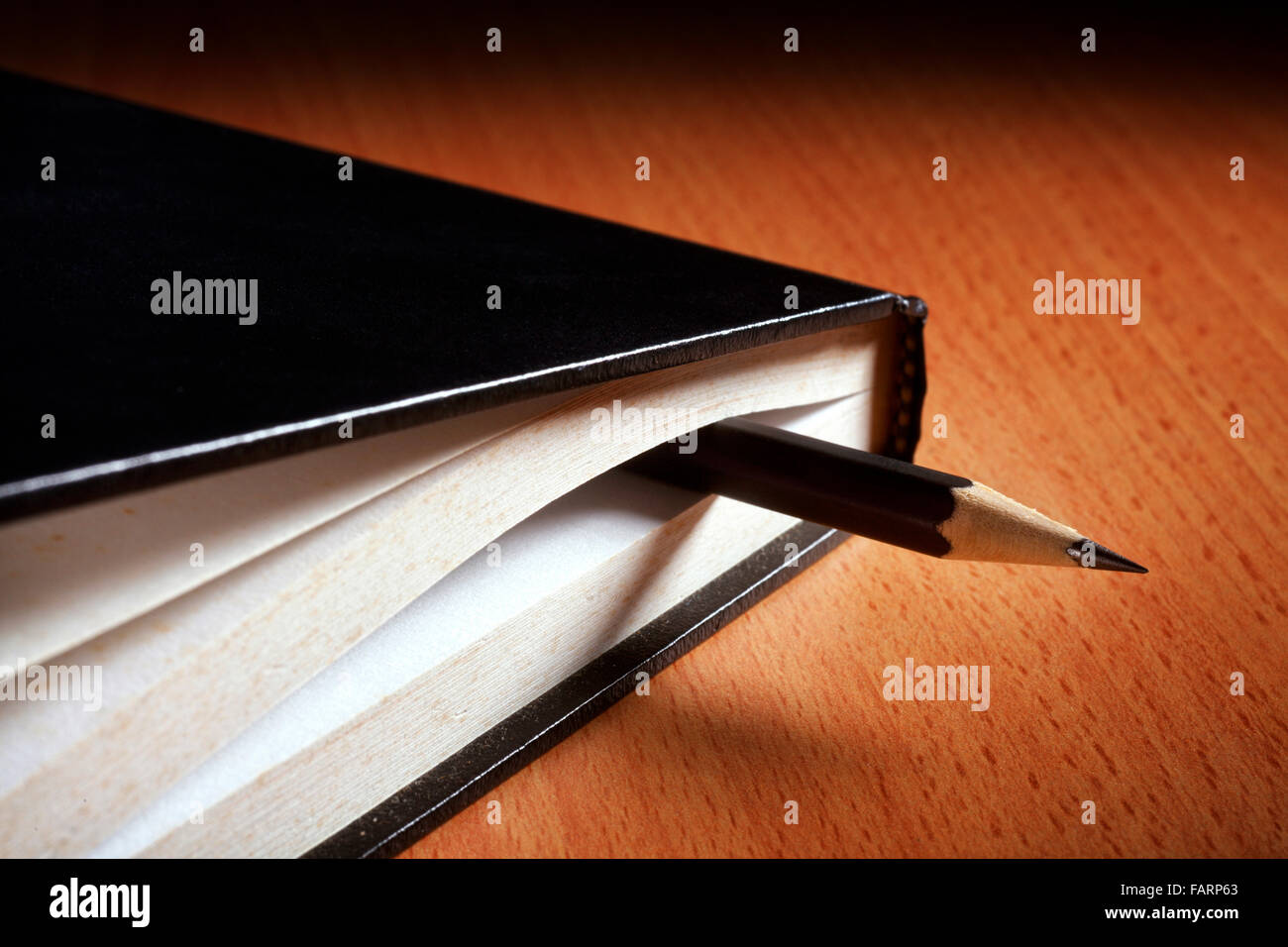 pencil in the closed book as book mark Stock Photo - Alamy