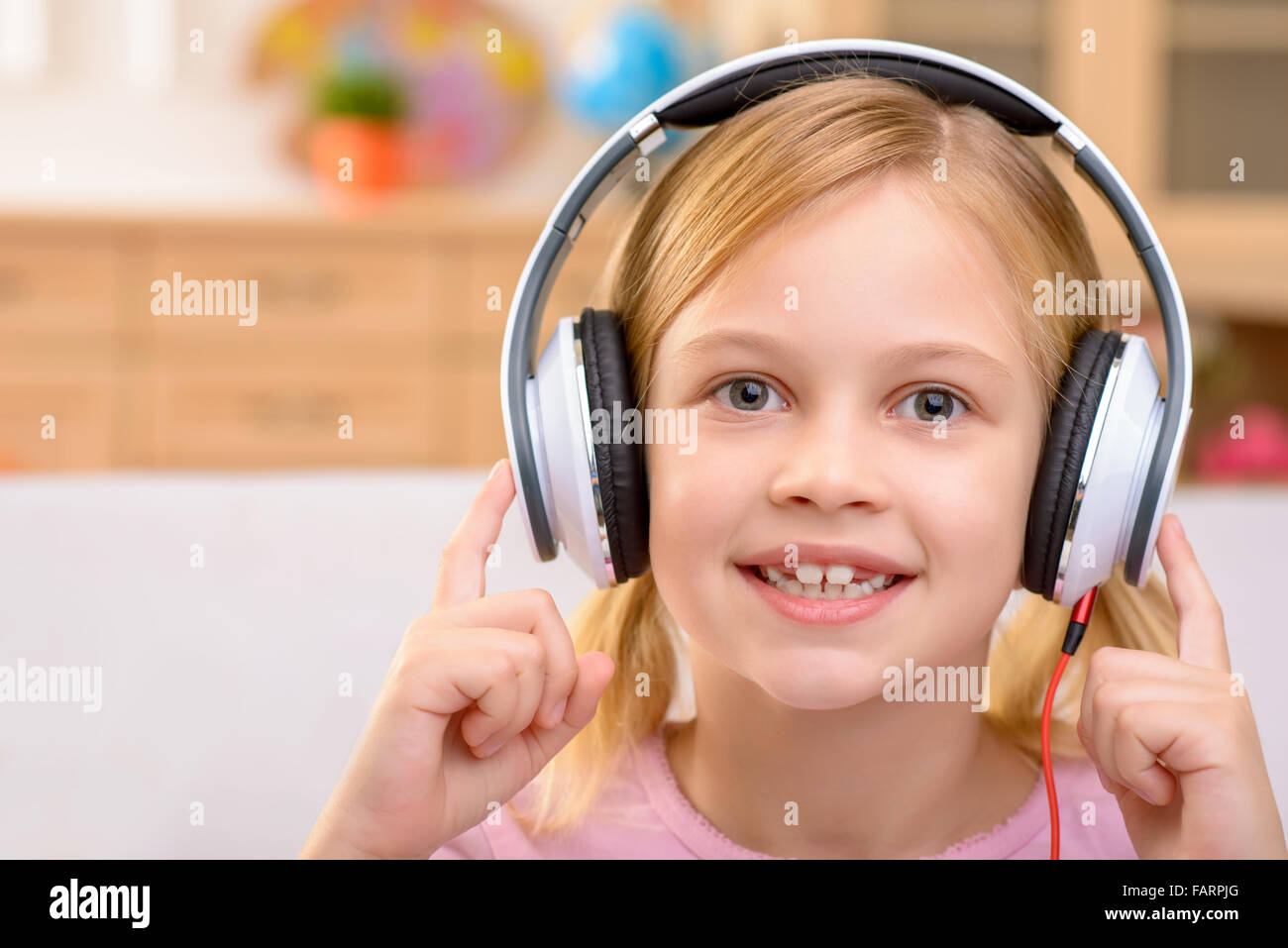 Vivacious little girl listening to music Stock Photo - Alamy