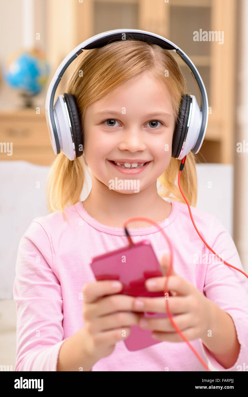 Vivacious little girl listening to music Stock Photo - Alamy