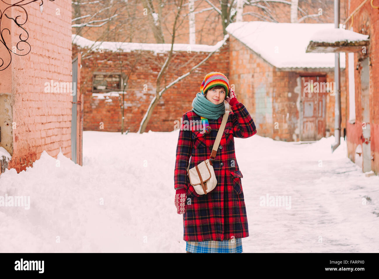 Girl in red checkered coat standing at old town background Stock Photo ...